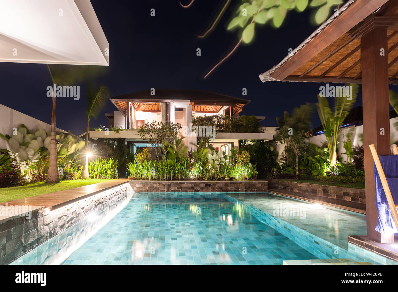 Modern house including a swimming pool in the middle illuminated with ...