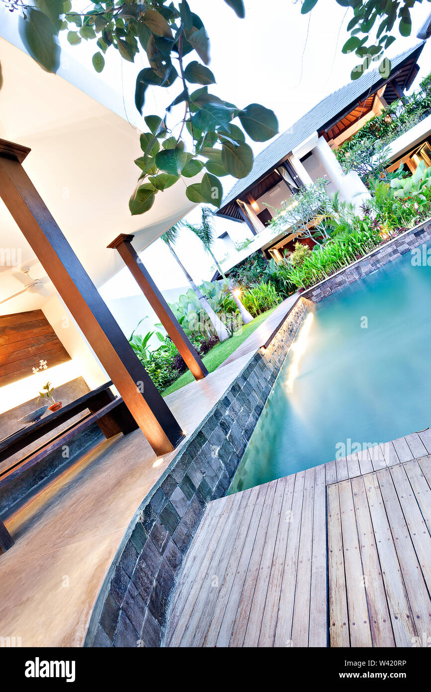 Modern swimming pool and wooden sidewalk around in a luxury house with ...