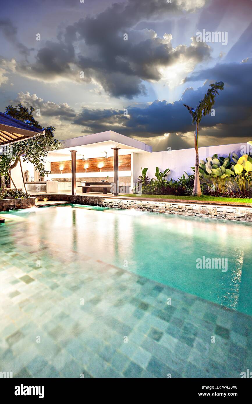 Modern pool water view over it with the garden and patio area beside ...