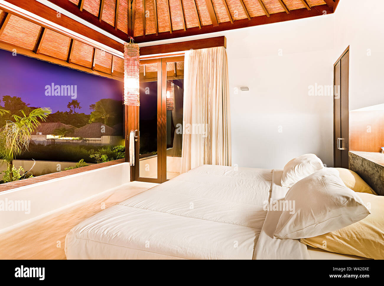 Outdoor bedroom at night with lights on and outside can be through the ...