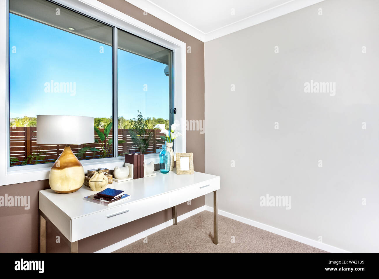 Simple study desk with décor items, books, and drawers Stock Photo - Alamy