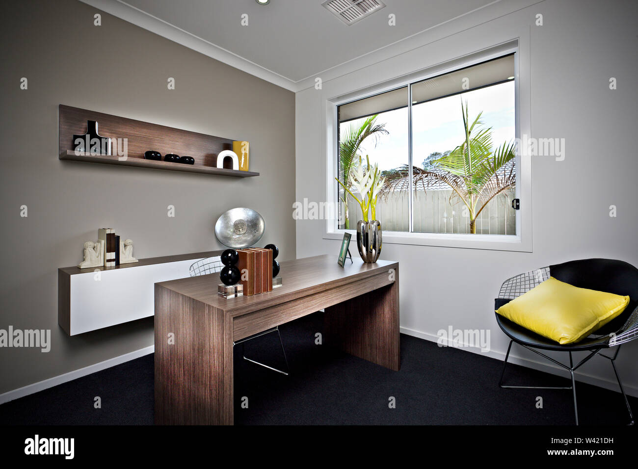 Modern work room with wooden table and fancy items on the surface and ...