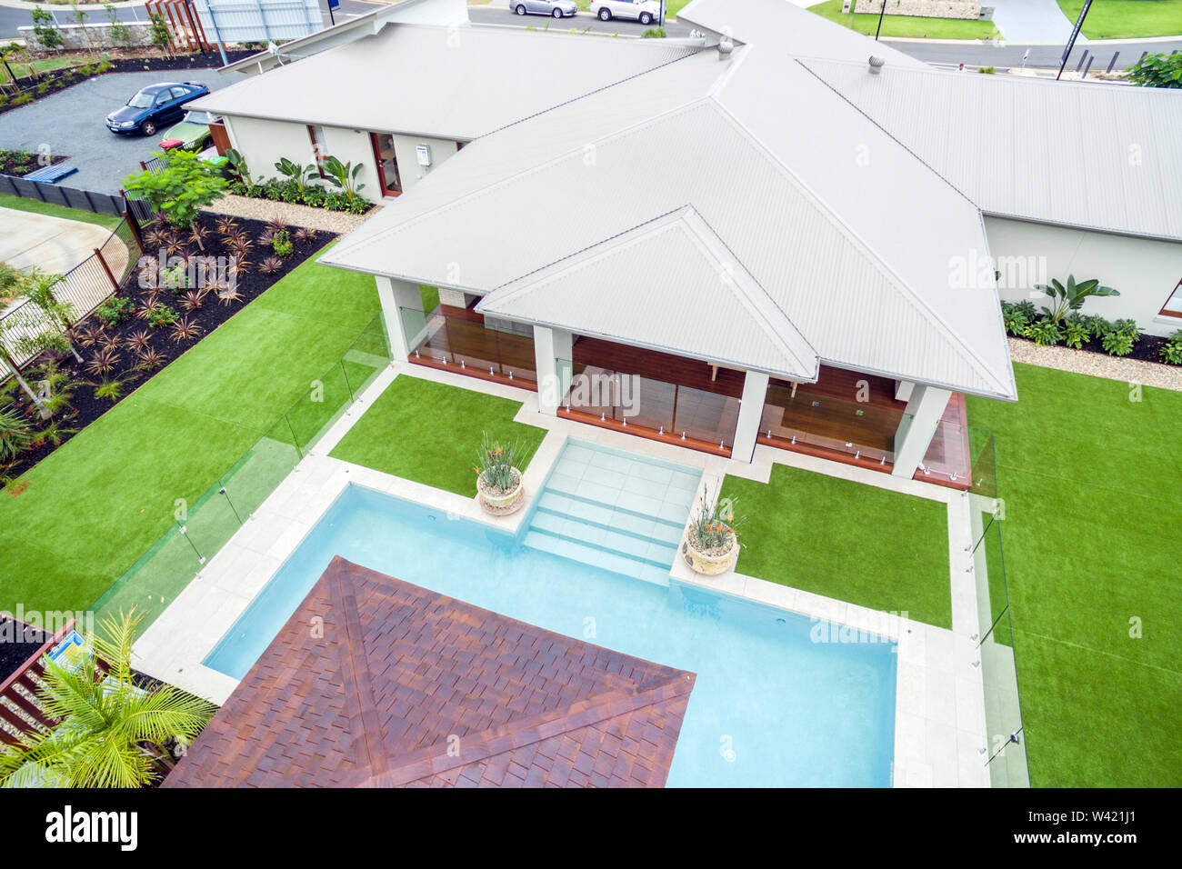 Backyard of the house with an attached pool and patio, covered with ...