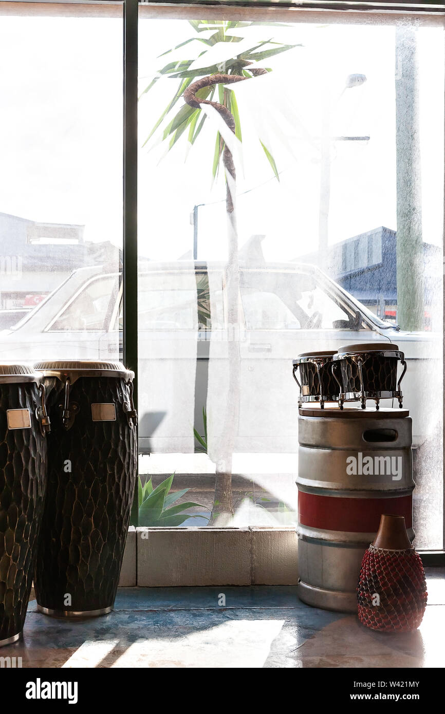 Musical instruments including bongo and drums in a room beside a glass ...