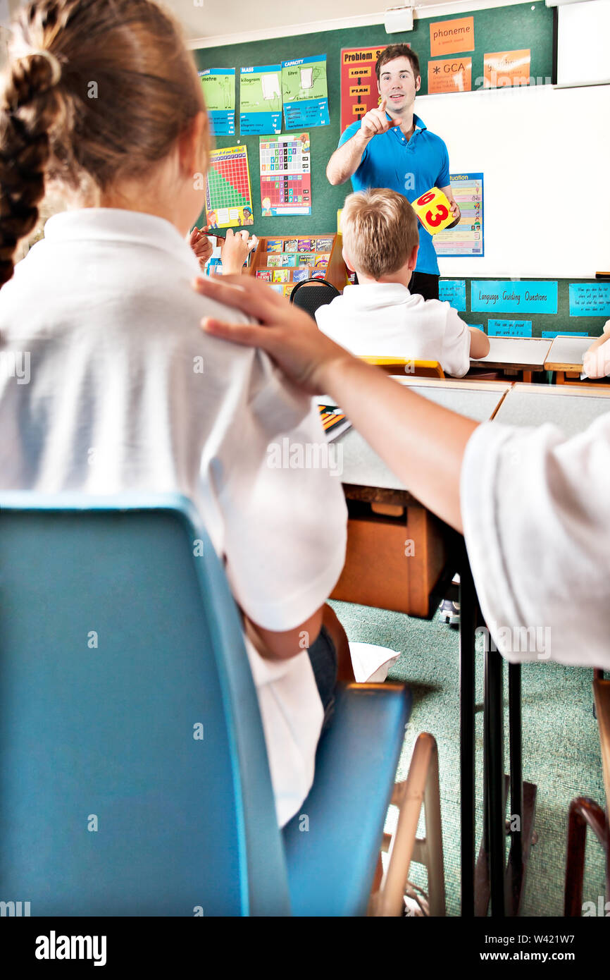 Young teacher is teaching for small students and asking questions in a ...