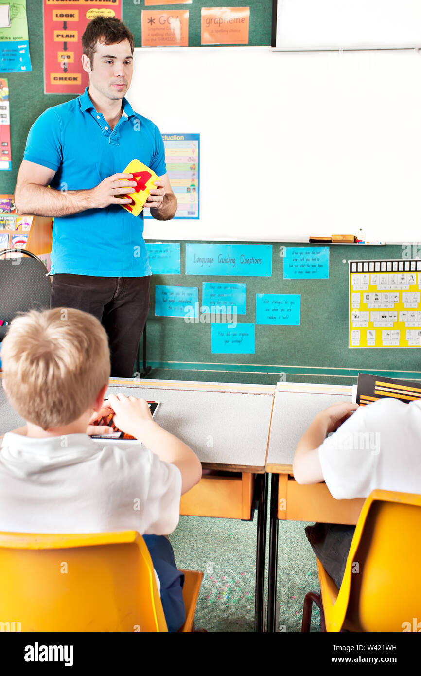 young teacher waits to get answers from the kids while teaching the ...