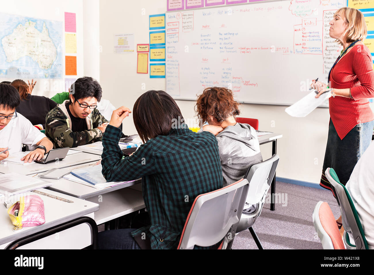 Lady teacher does a lesson, students in the school and children are ...