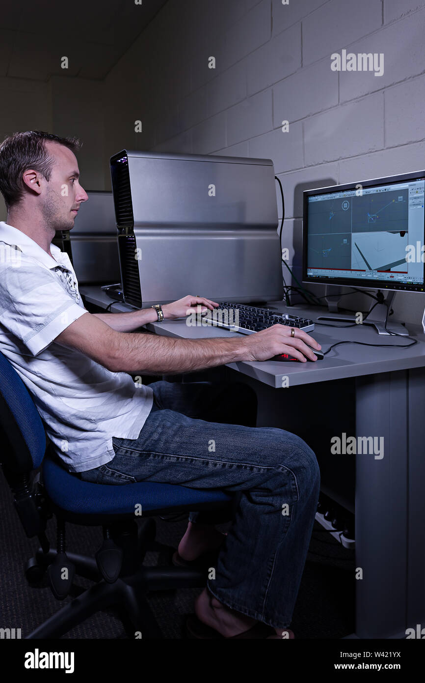 Man operating his own personal computer in a room sitting on an office ...