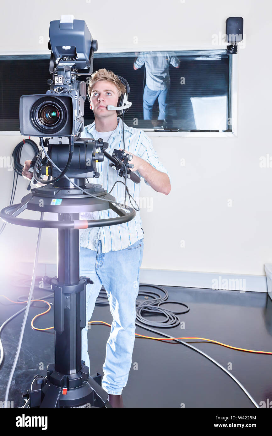 Person operating a studio camera and ready to shoot in a the room the ...