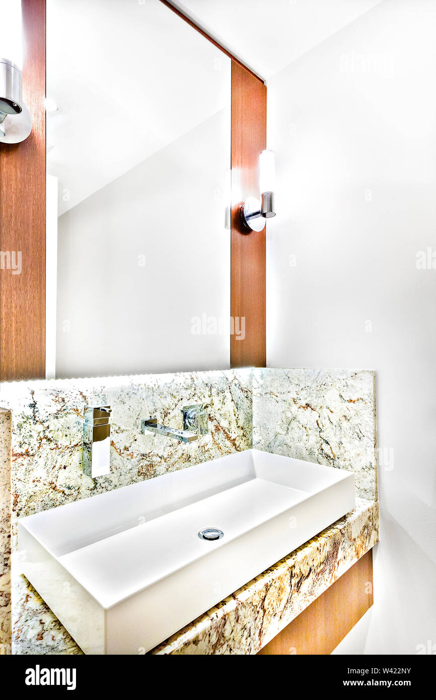 Modern wash area with ceramics and mirror, floor is tiled, walls are ...