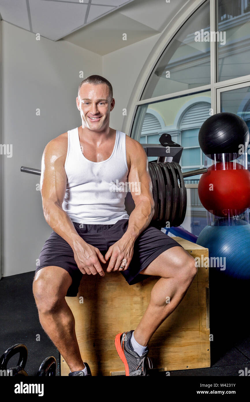 Man relaxing after work out on chair, inside room of a luxury gym ...