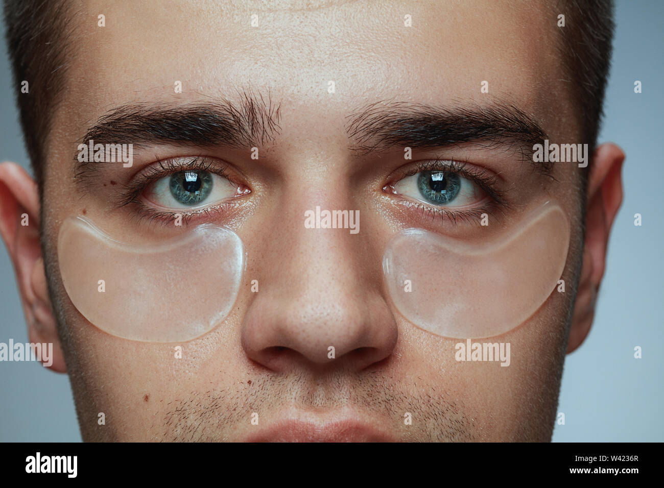 Close-up profile portrait of young man isolated on grey studio ...