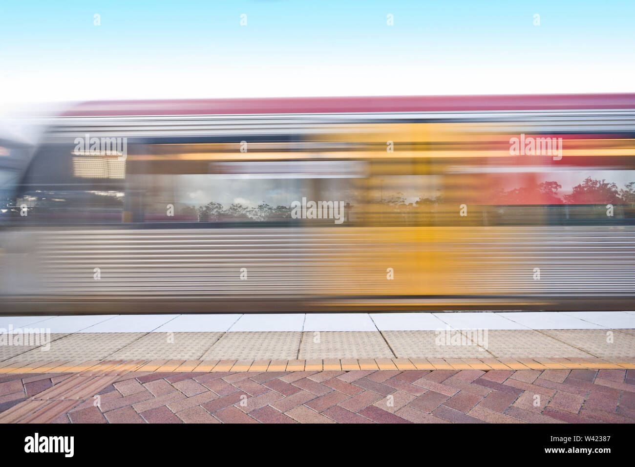 Electric train stopped at station floor, sunlight around the area ...
