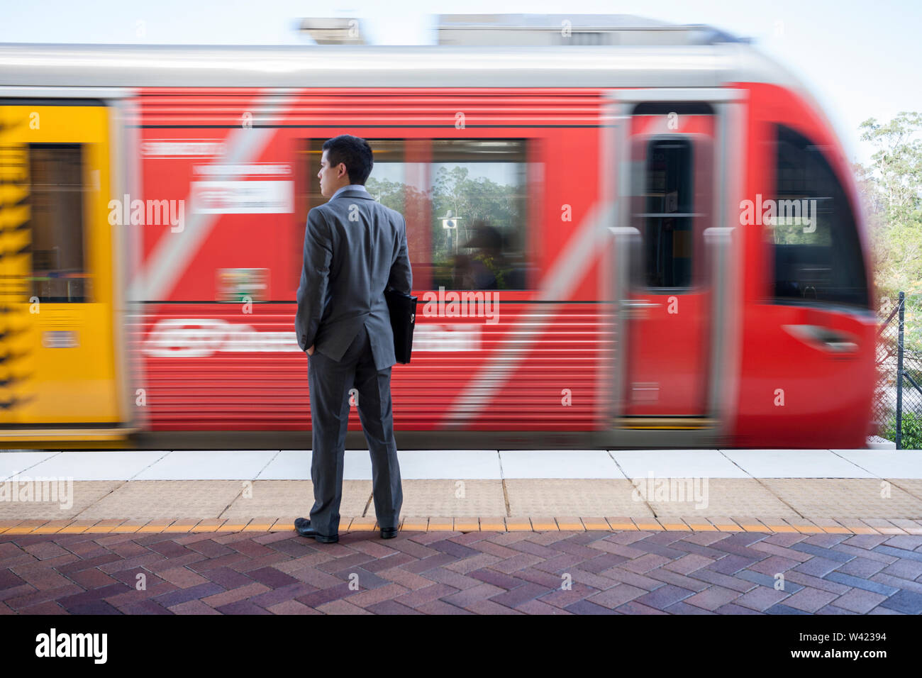 Red color train stopped infront of man, sunlight around the area ...