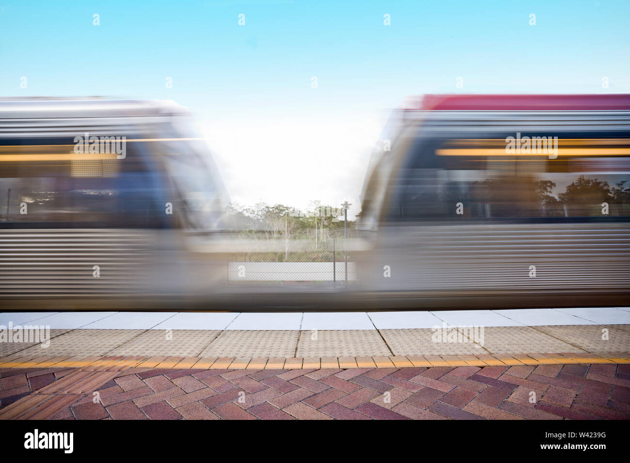 Fast trains moving forward infront of station, sunlight around the area ...