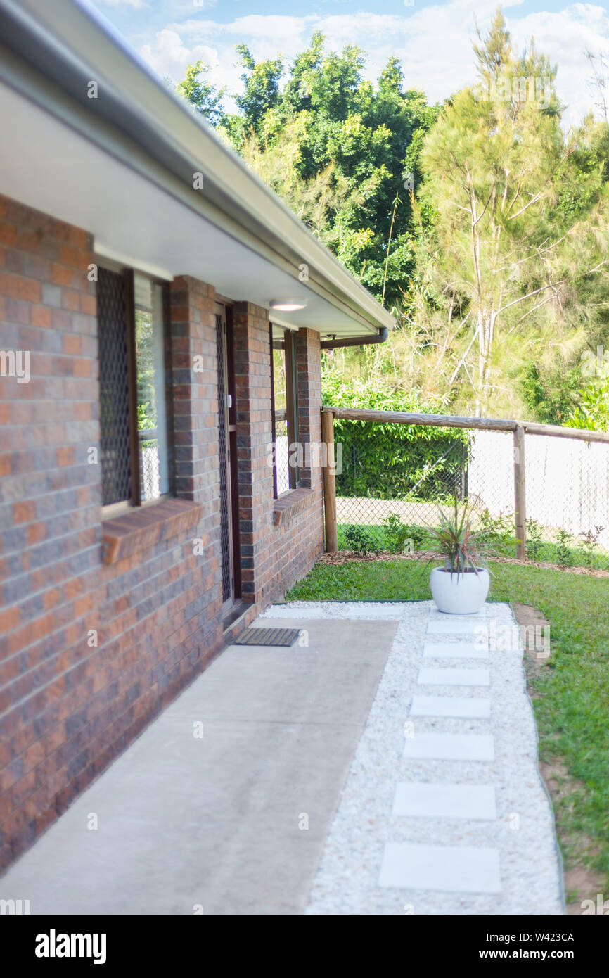 View of the backyard area of a house featuring a cement pavement and ...