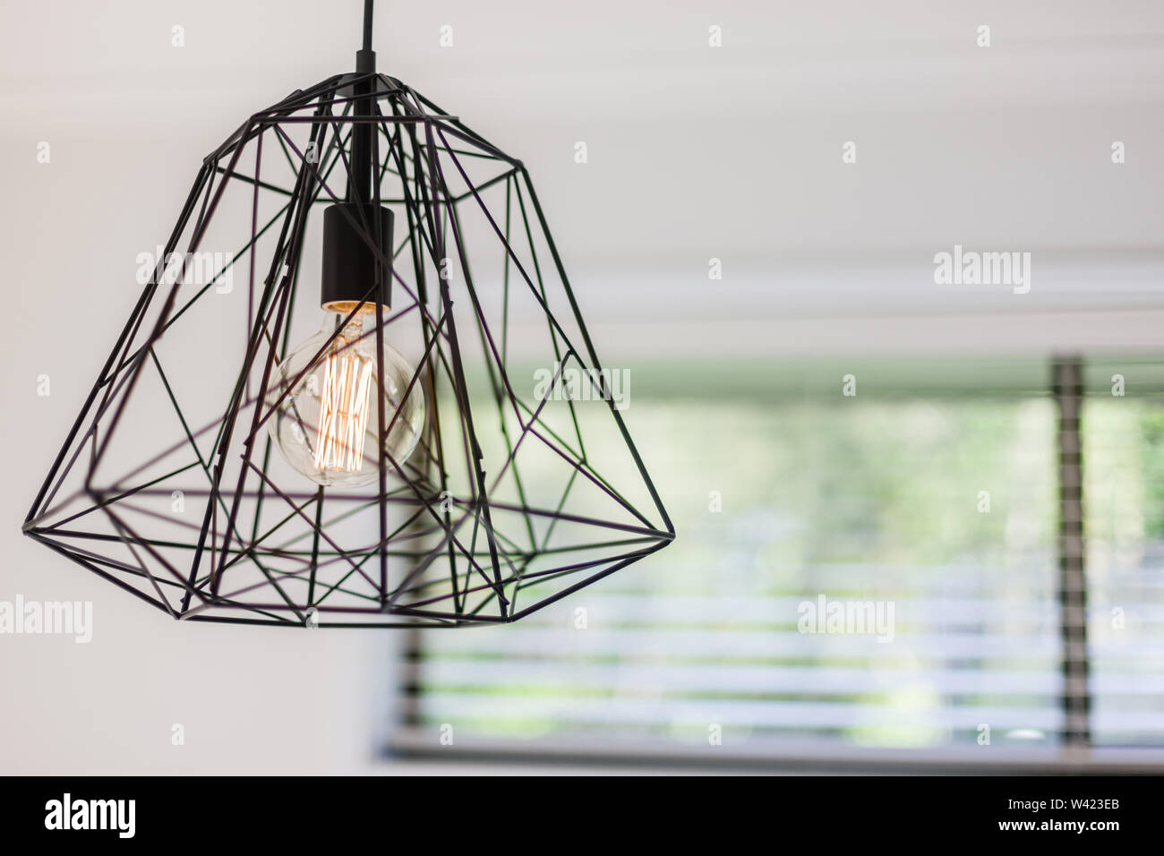 Close view of a contemporary cage design ceiling light with the bulb ...