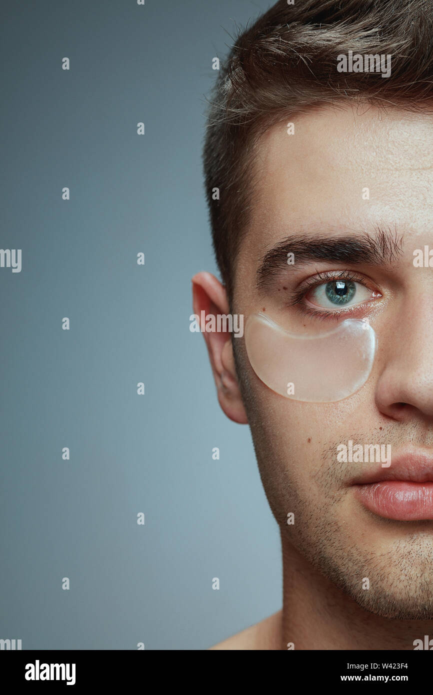 Close-up profile portrait of young man isolated on grey studio ...