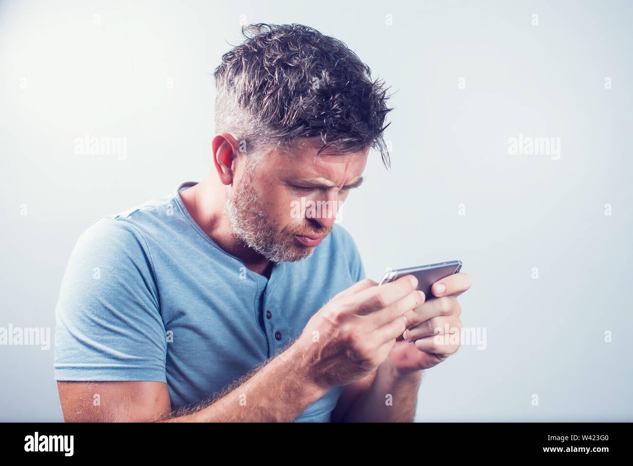Handsome young man using mobile phone isolated Stock Photo - Alamy