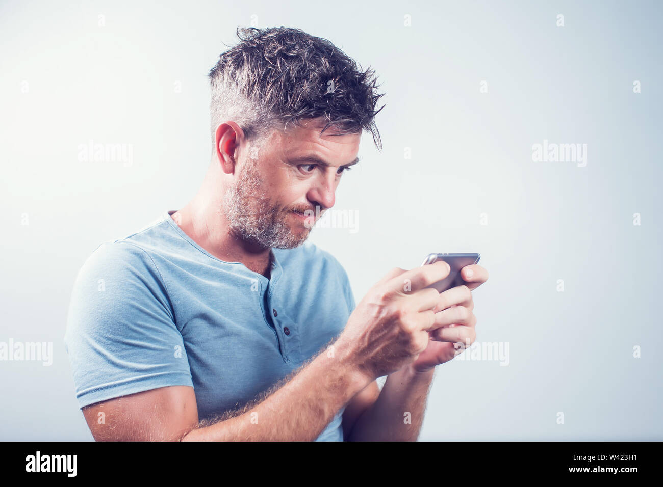 Handsome young man using mobile phone isolated Stock Photo - Alamy