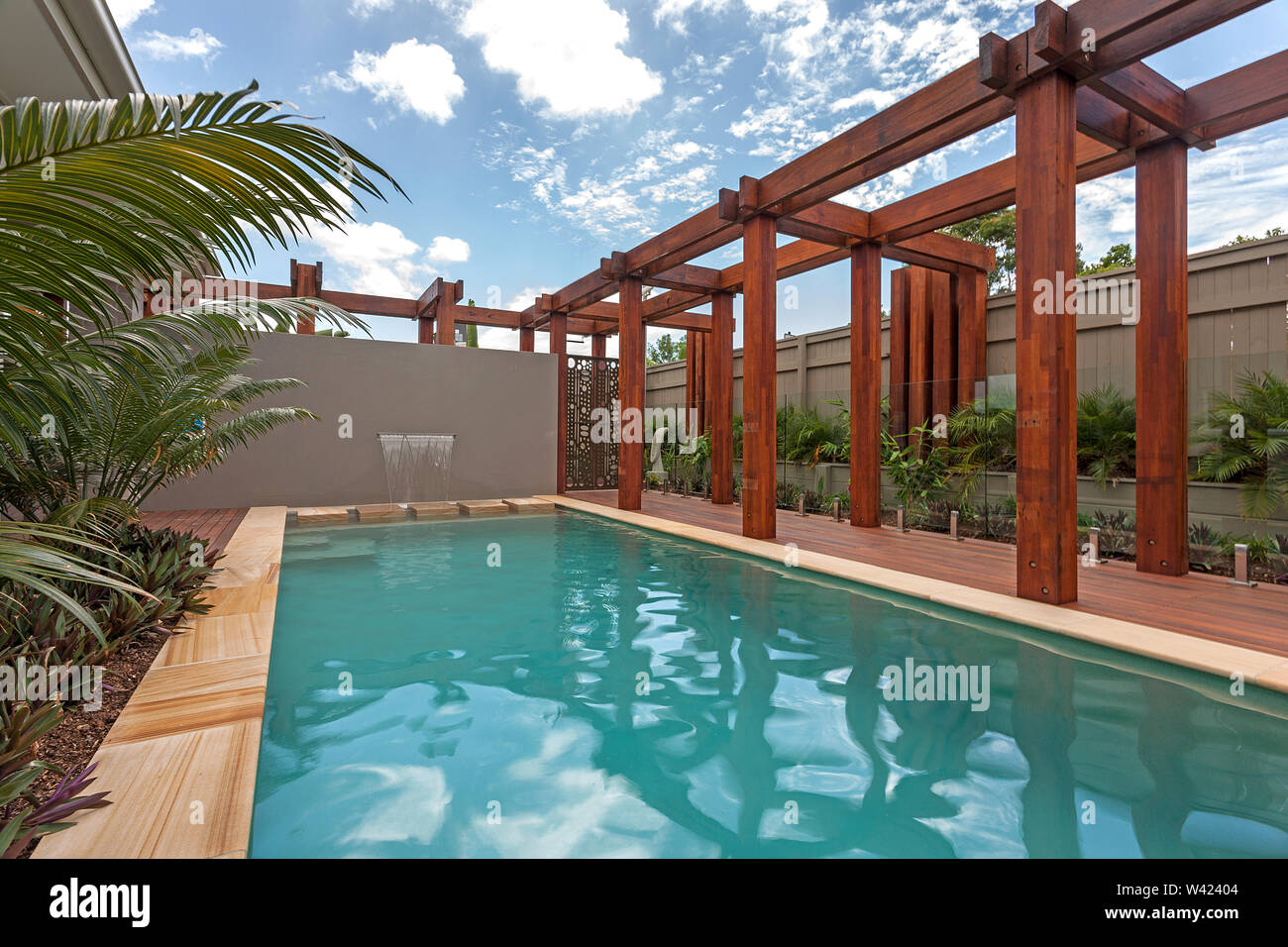 Amazing pool view with a tiled boundary and wooden pavement and pillar ...