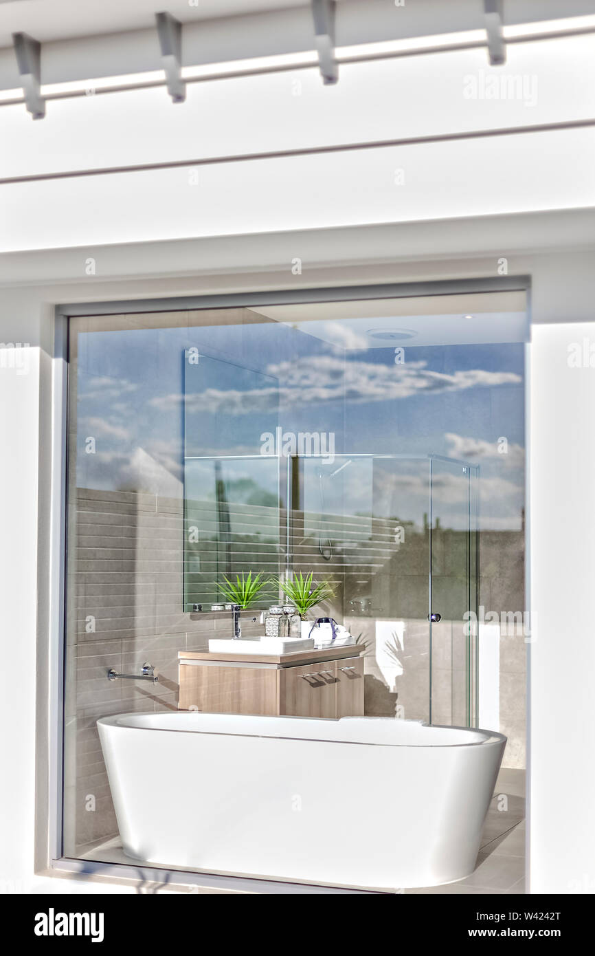 Modern bathroom can be seen through the glass window of a modern house ...
