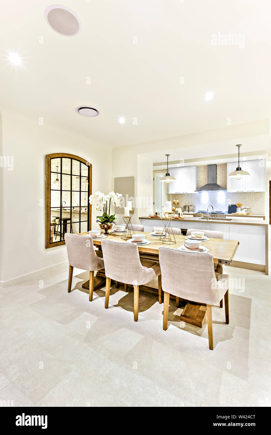 Dining table set up with a kitchen in a house with lights at night ...