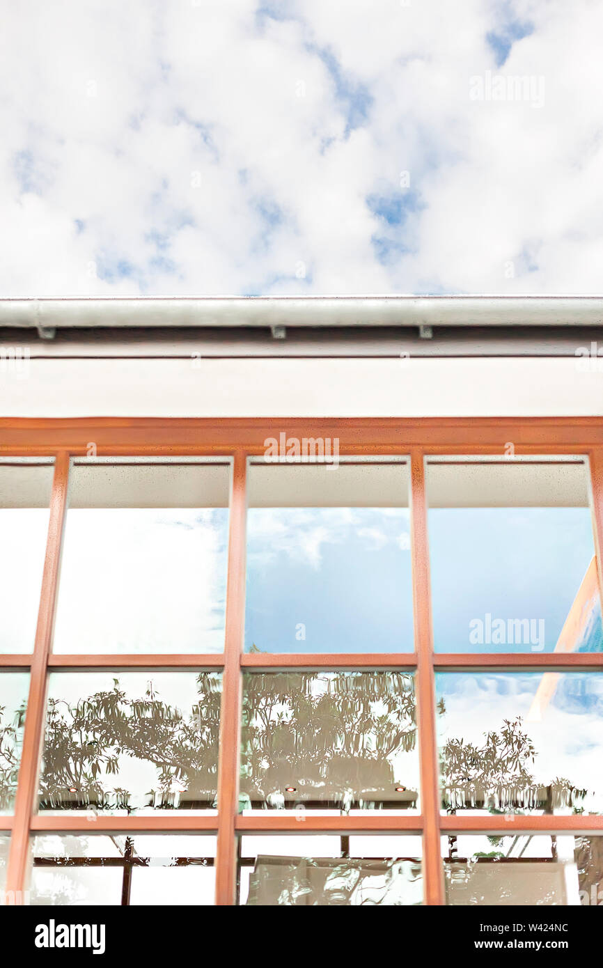 Modern building with glass panels and wooden windows with reflection ...