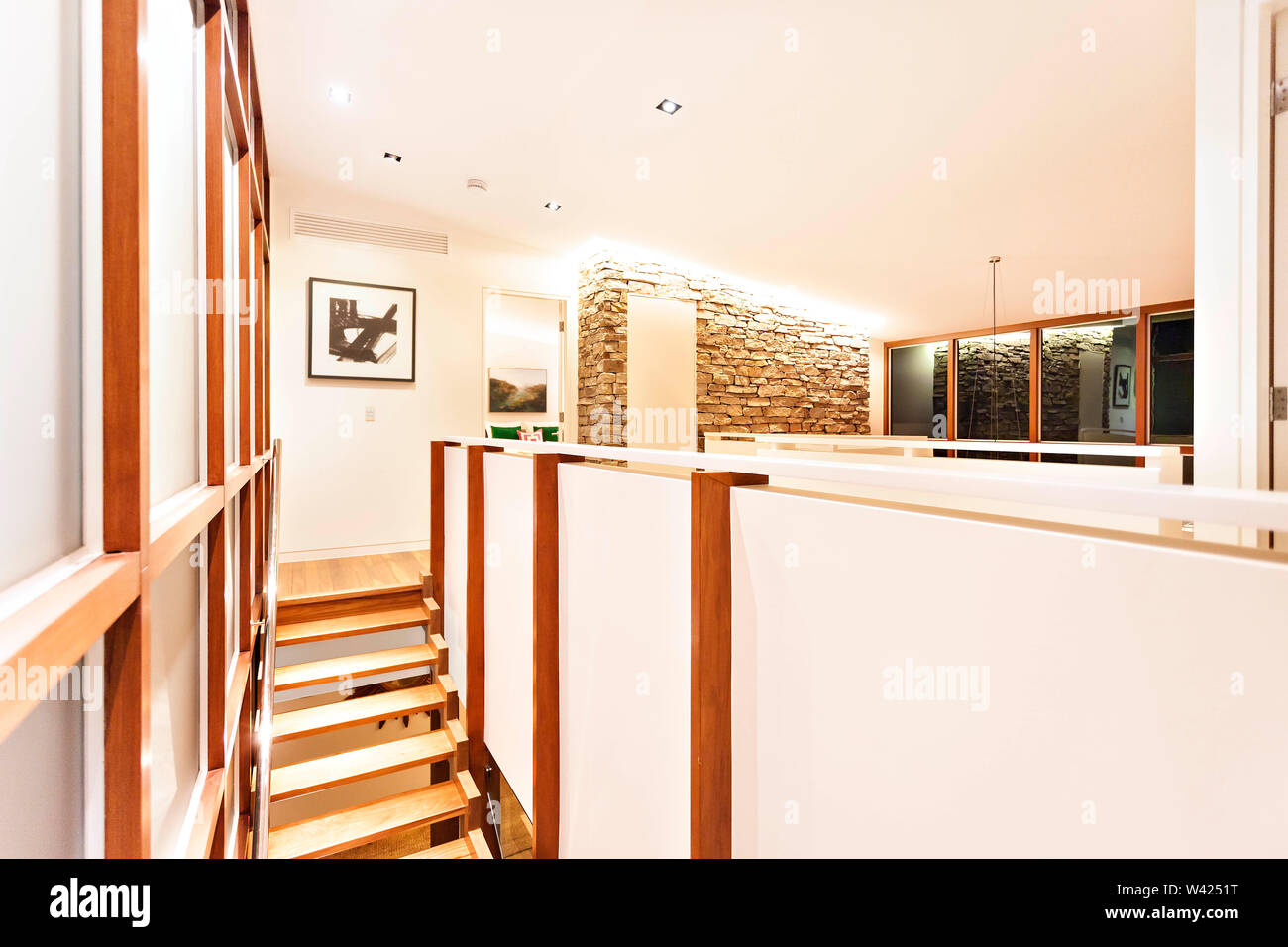 Modern house upstairs with wooden staircase and white walls around with ...