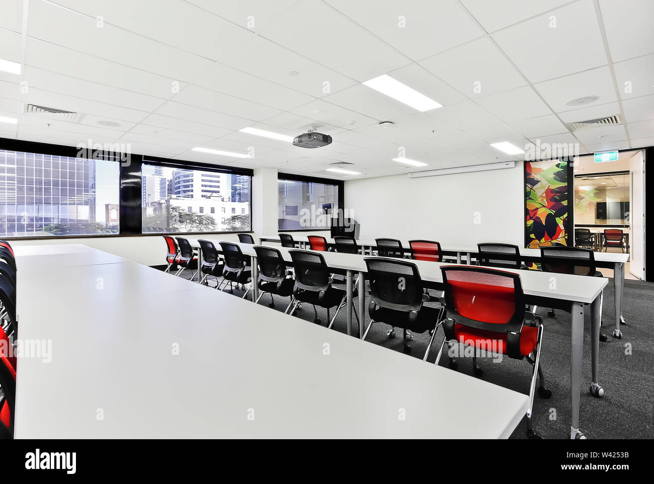 Modern meeting hall with long tables and chairs covered with white ...