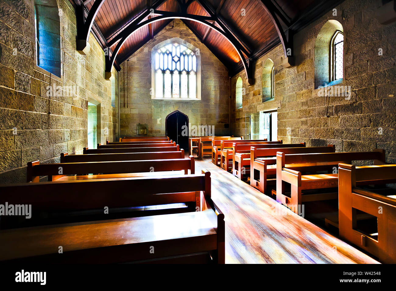 Old style of the Church room with wooden chairs and stone walls ...