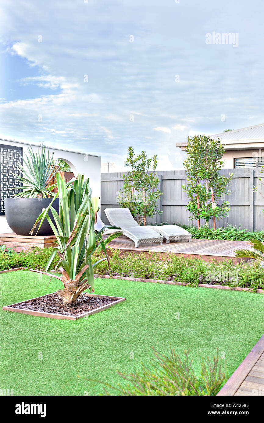 House with outdoor garden with green lawn and patio area including a ...