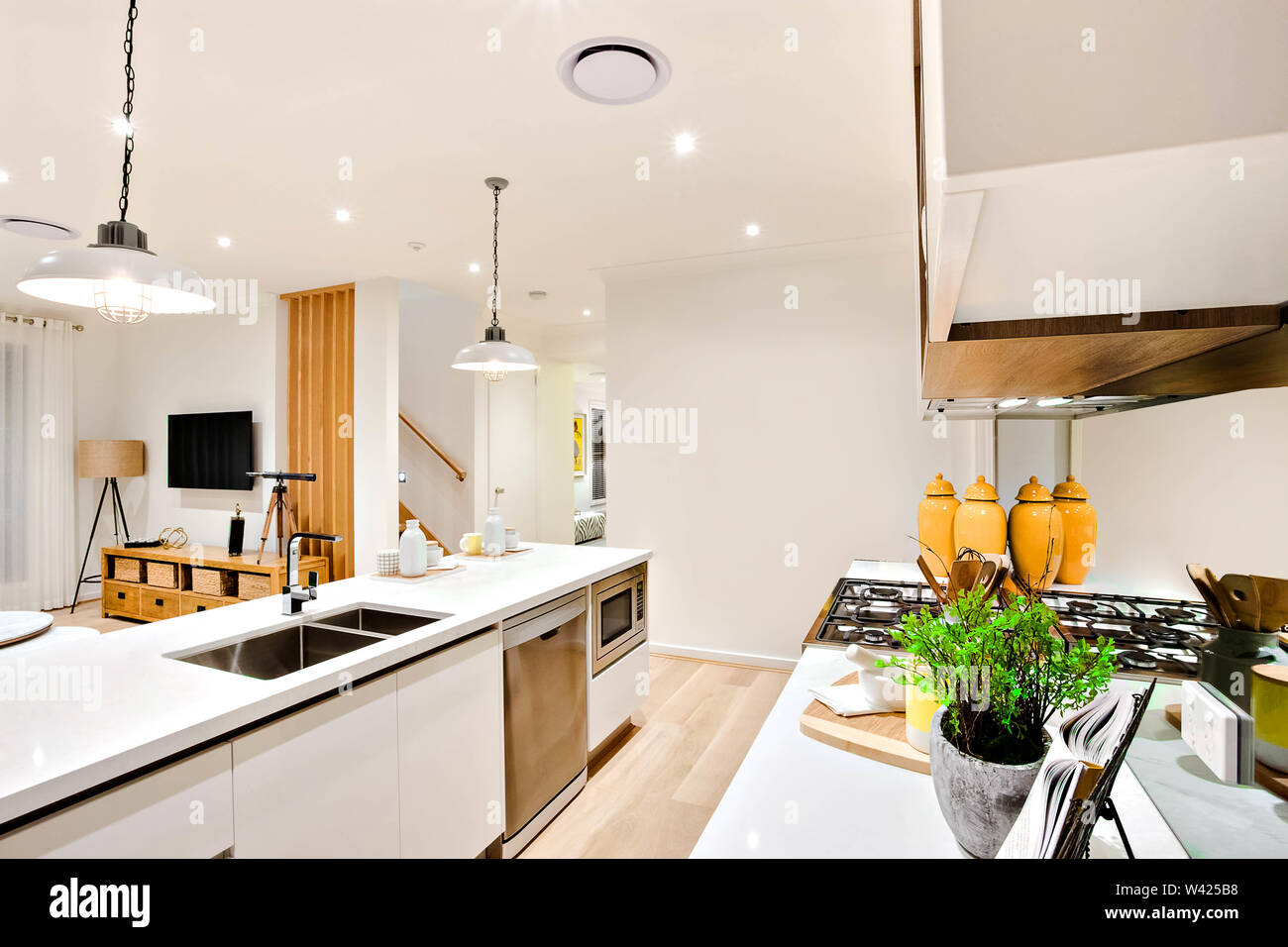 Modern kitchen closeup with white walls and hanging lamps over the ...