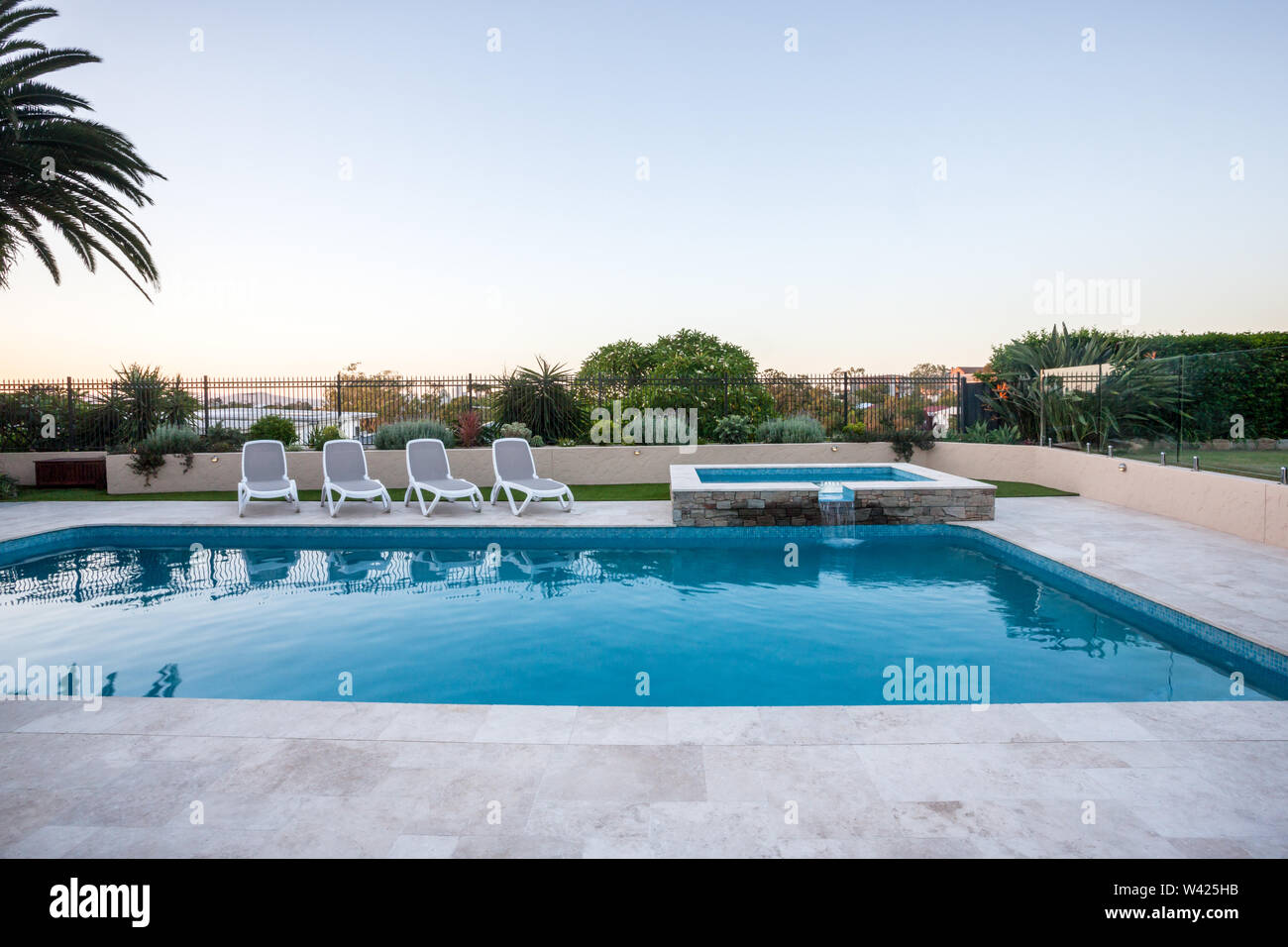 Luxury swimming pool with a small fountain covered with fence beside ...