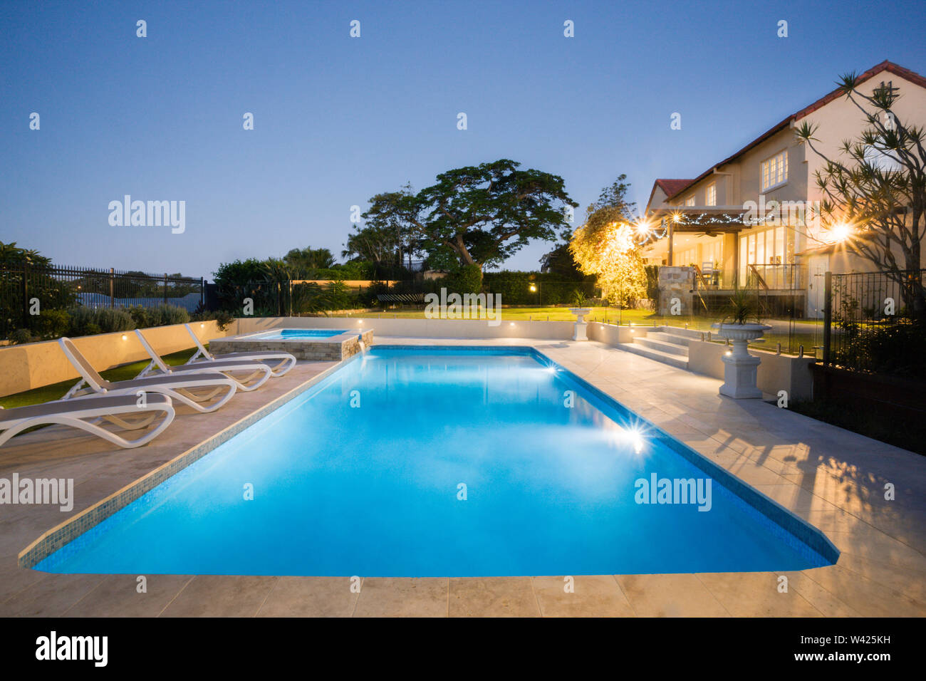 Luxury swimming pool with blue water at night with flashing lights from ...