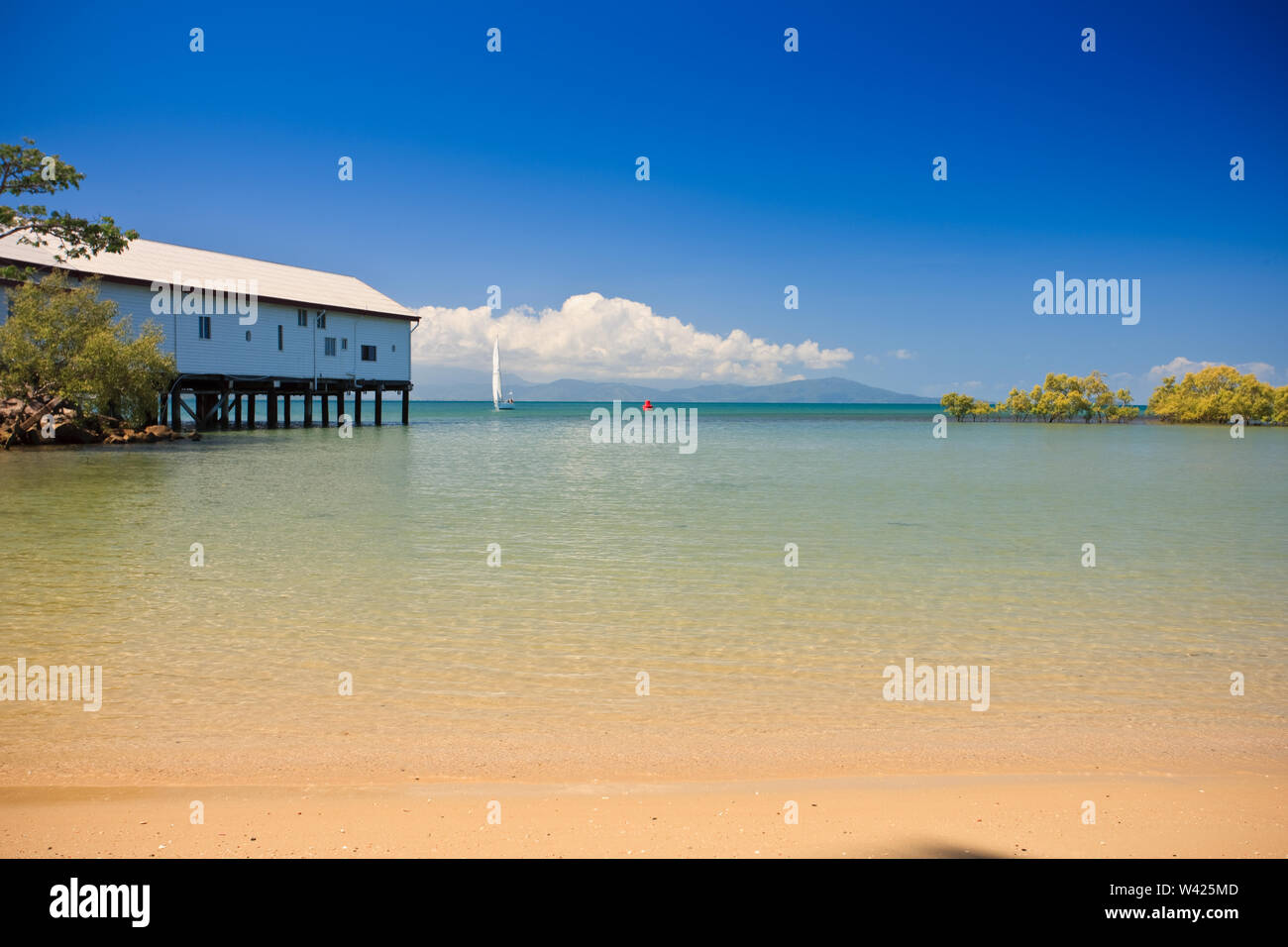 A relaxing seascape with a sailing dinghy yacht and a dock house Stock ...