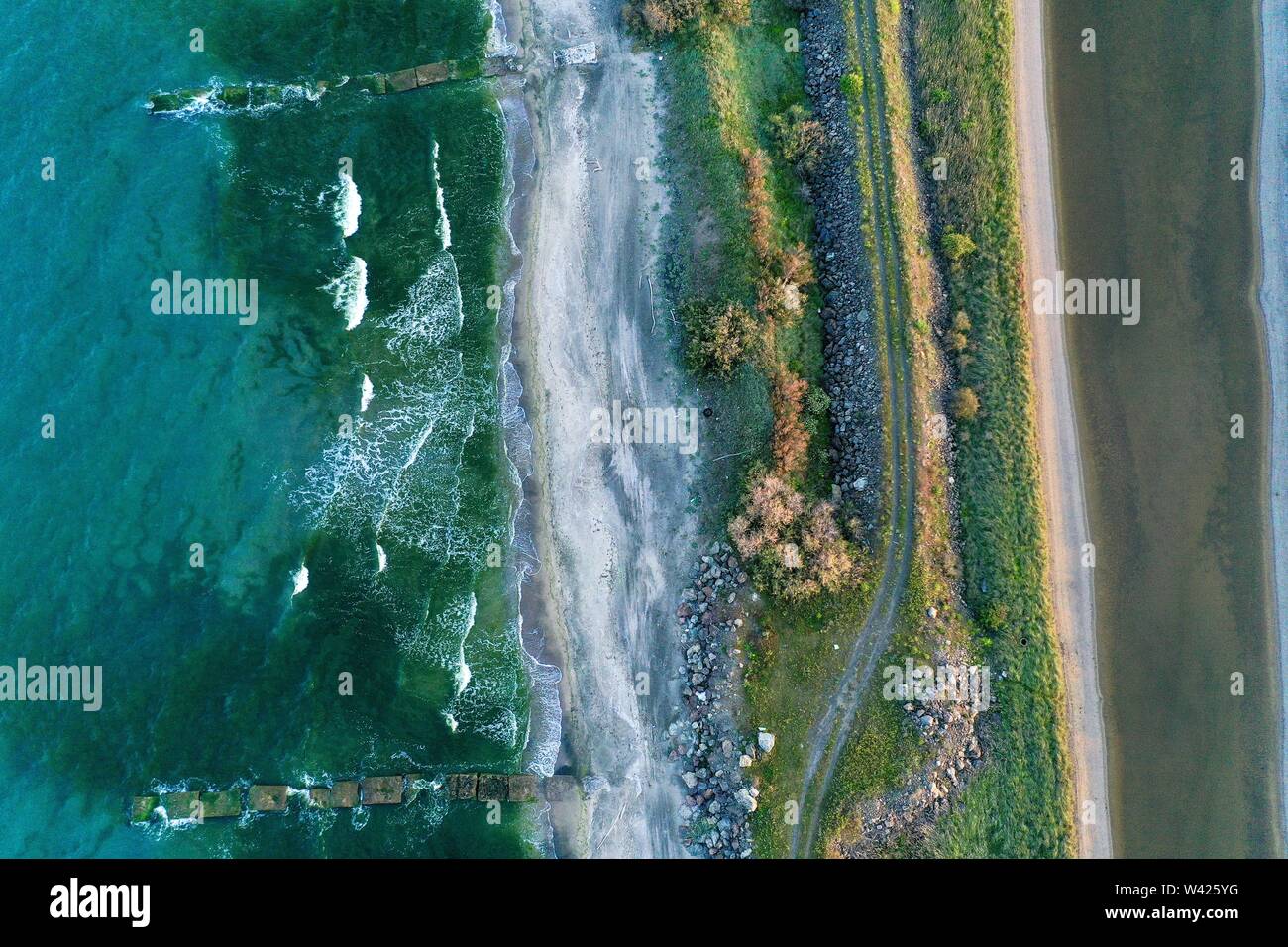 Overhead shot of a narrow shore in the middle of the sea with pathway ...