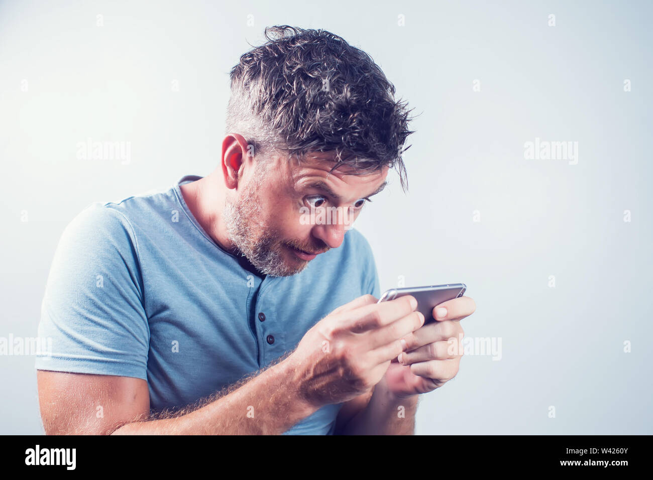 Handsome young man using mobile phone isolated Stock Photo - Alamy