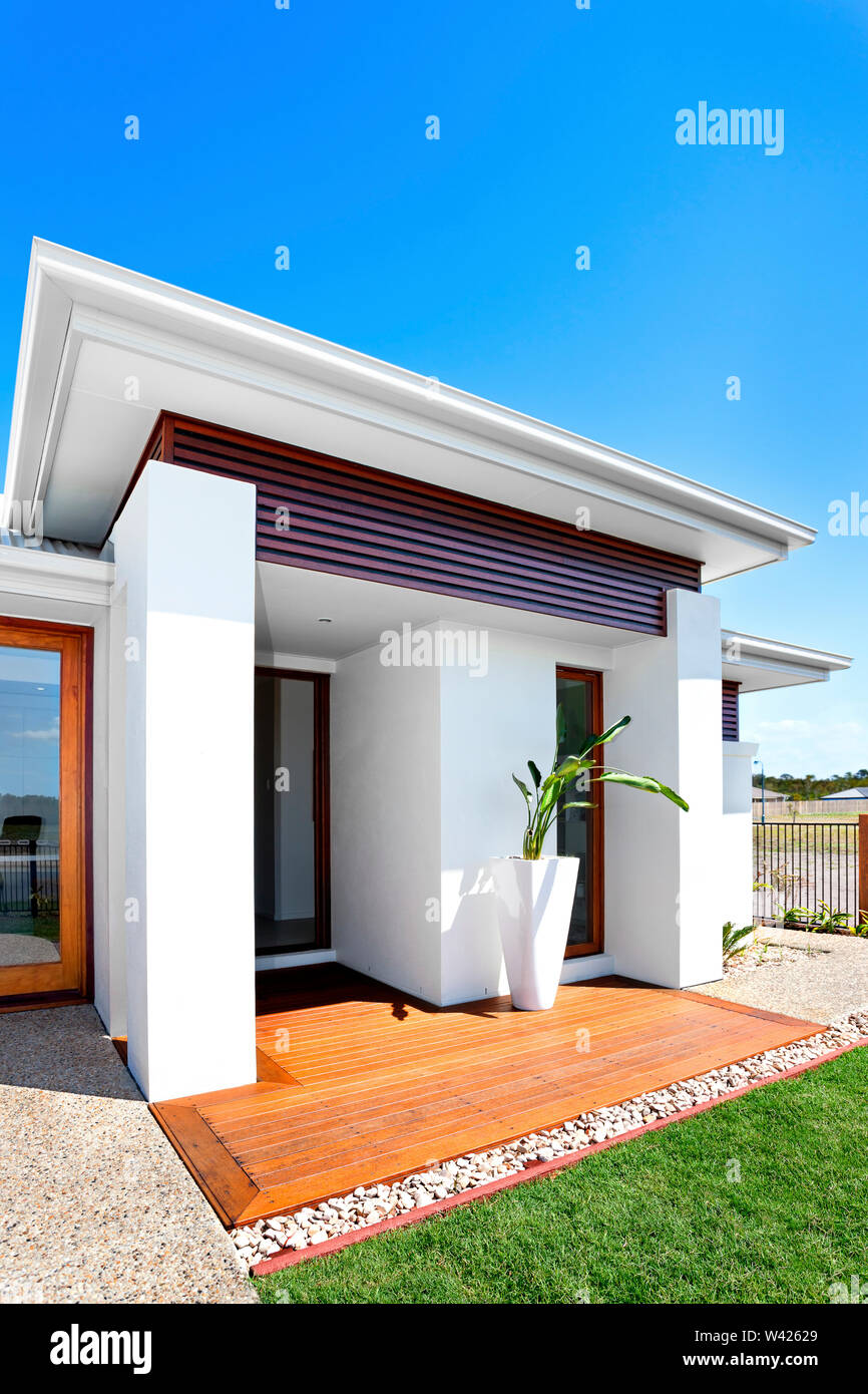 Outdoor of a modern house with green lawn, front view from the left ...