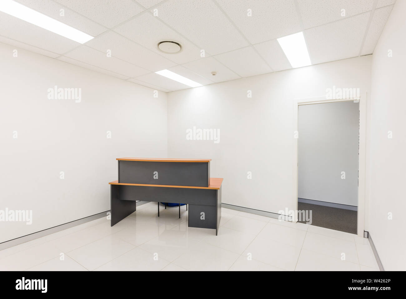 The quirky wood finish table with an orange top in an white room kept ...