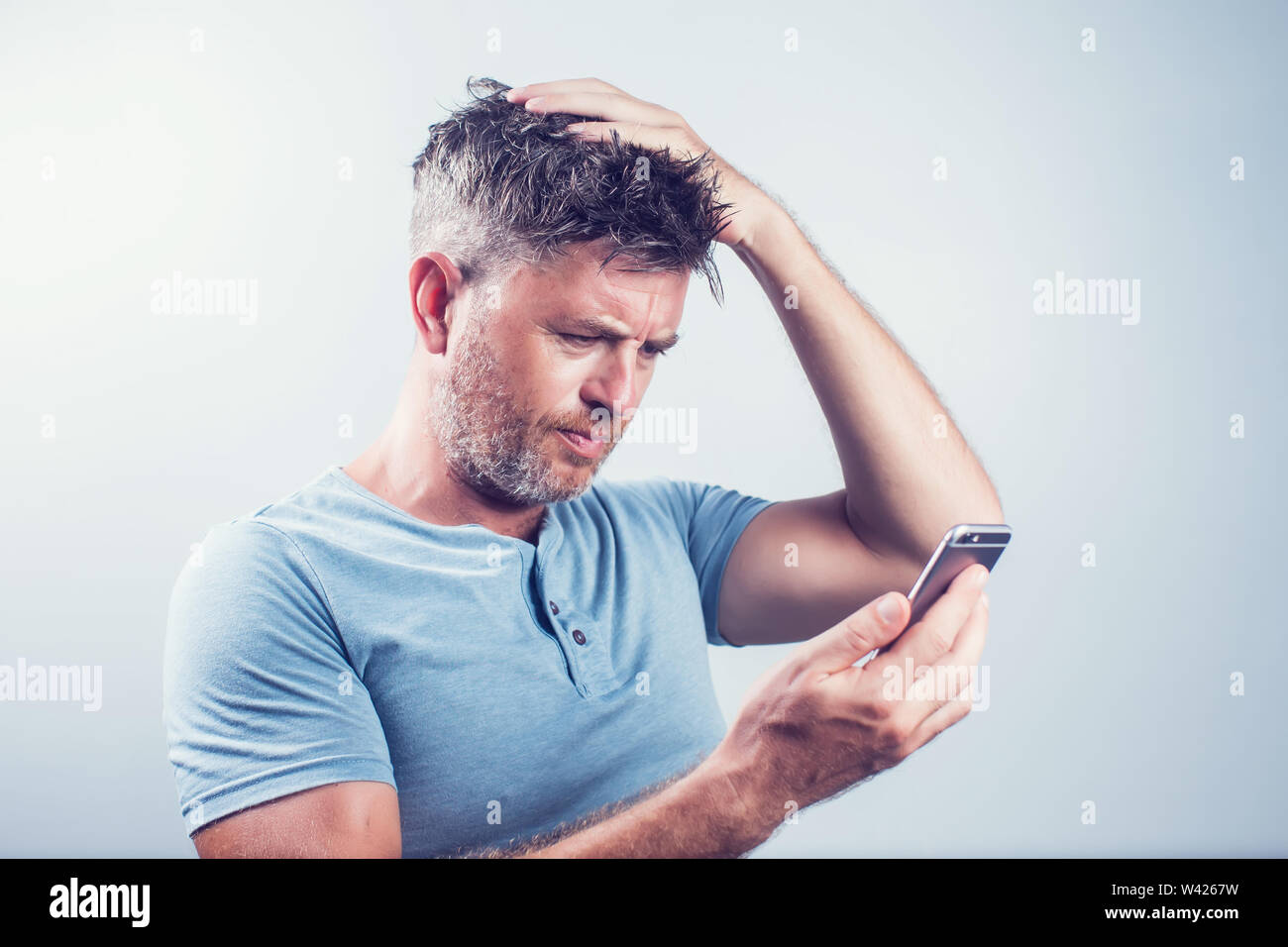 Handsome young man using mobile phone feel sad Stock Photo - Alamy