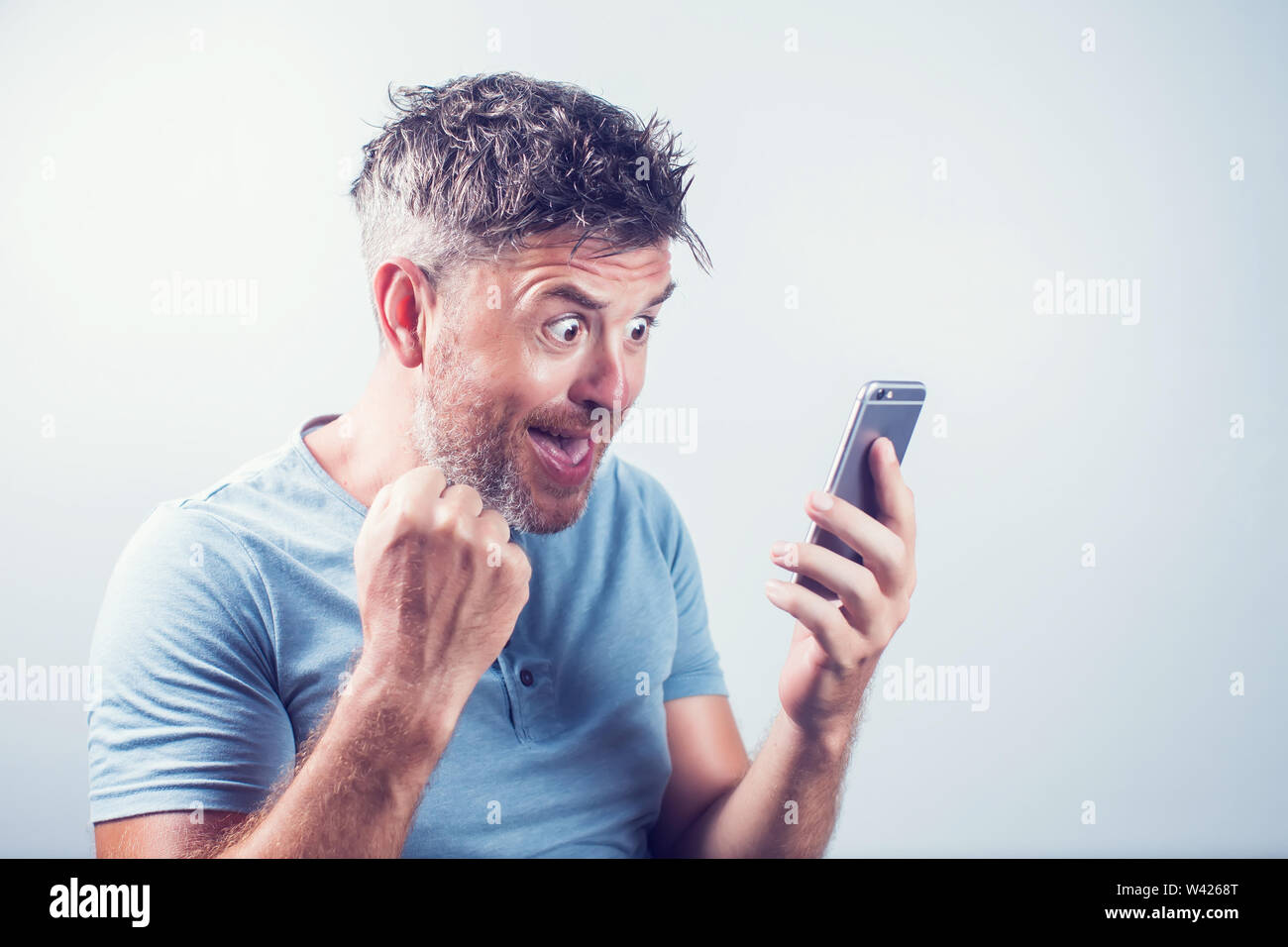 Handsome young man using mobile phone isolated Stock Photo - Alamy