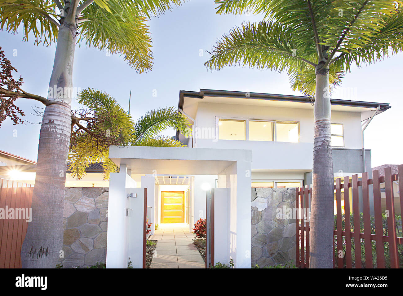 Luxurious home entrance with natural trees and rocky walls, two big ...