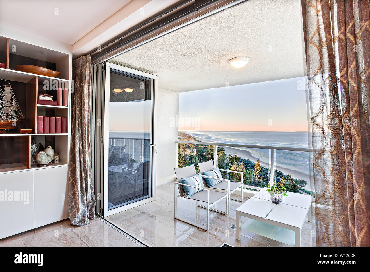 A remarkable balcony featuring a tiled floor, comfortable seating, and ...