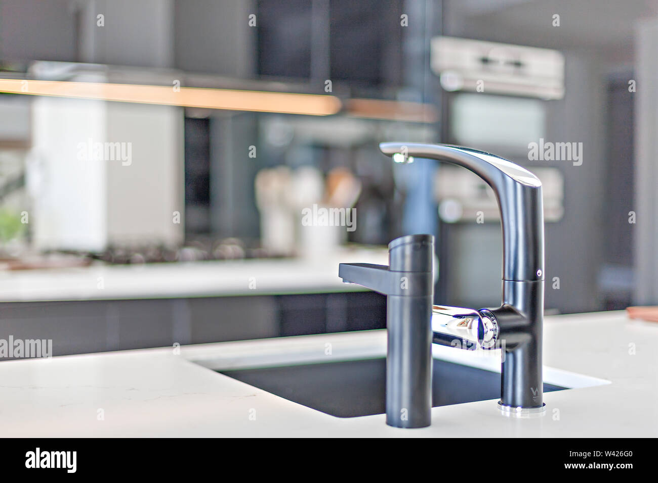 Modern kitchen taps on the kitchen counter basin Stock Photo - Alamy