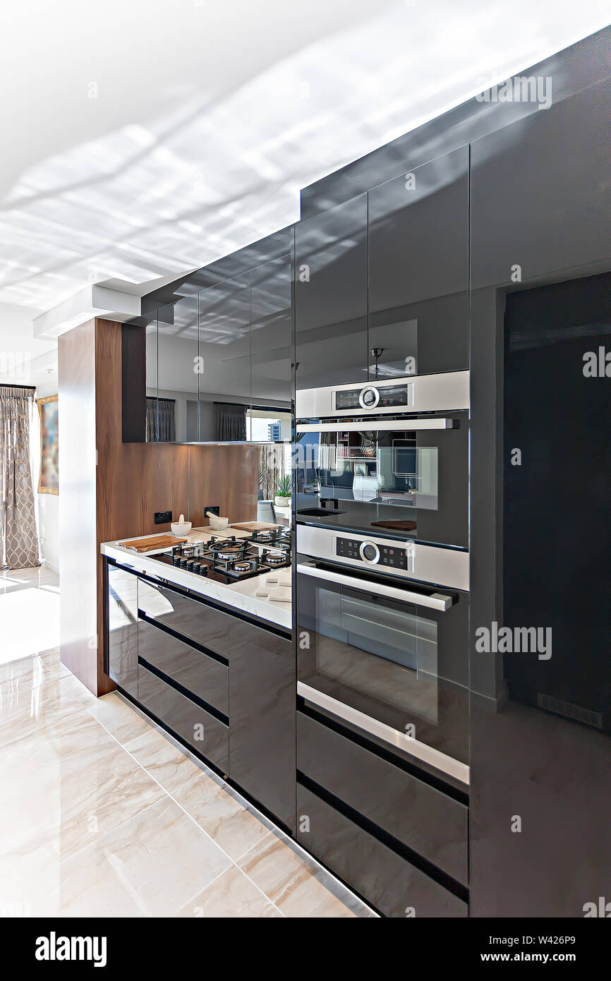 Modern kitchen cabinetry with gas hob on the counter and electronic ...