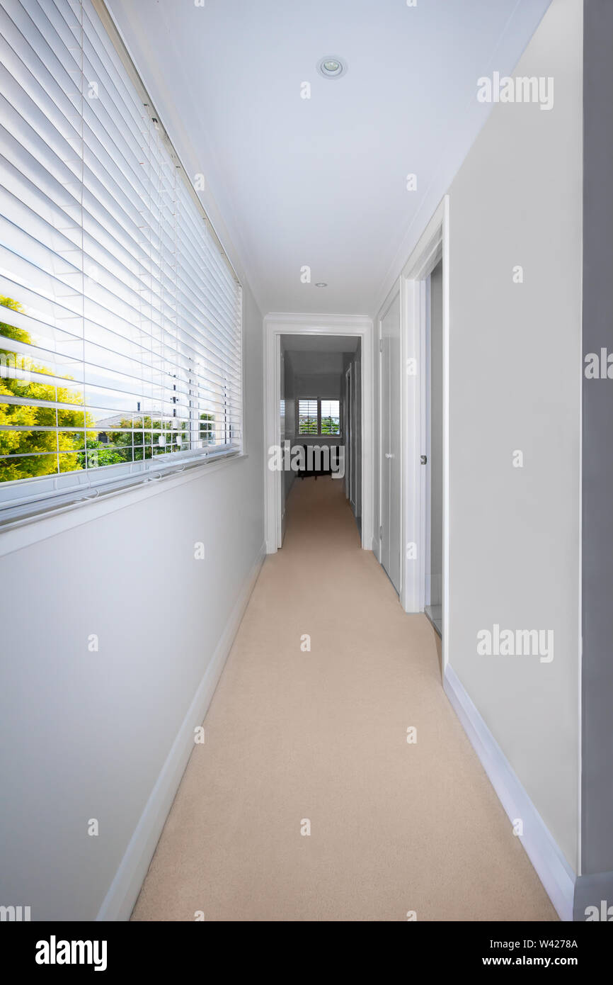 Long empty hallway with a big window covered with louvre Stock Photo ...