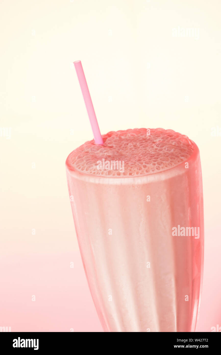 Natural fruit juice with colors in glass, pink color cup and background ...