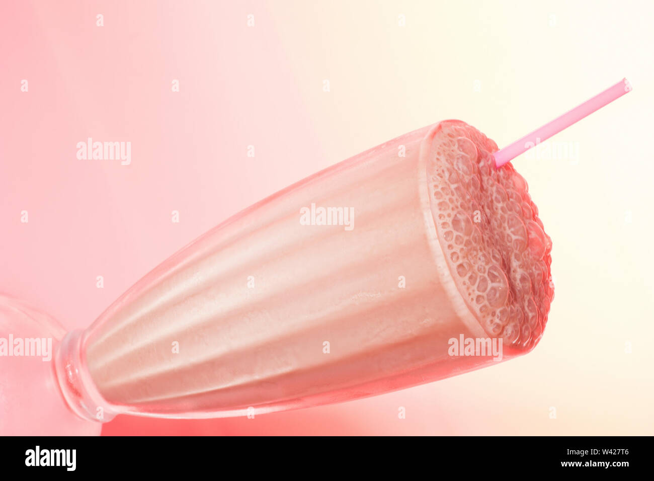Side view of a fruit juice glass, pink color cup and background ...