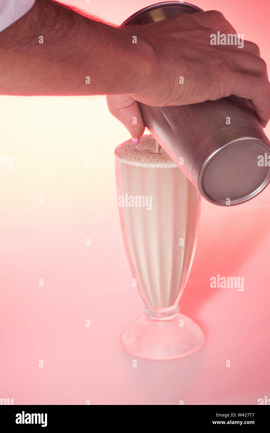 Chef making fruit juice in kitchen, pink color cup and background ...